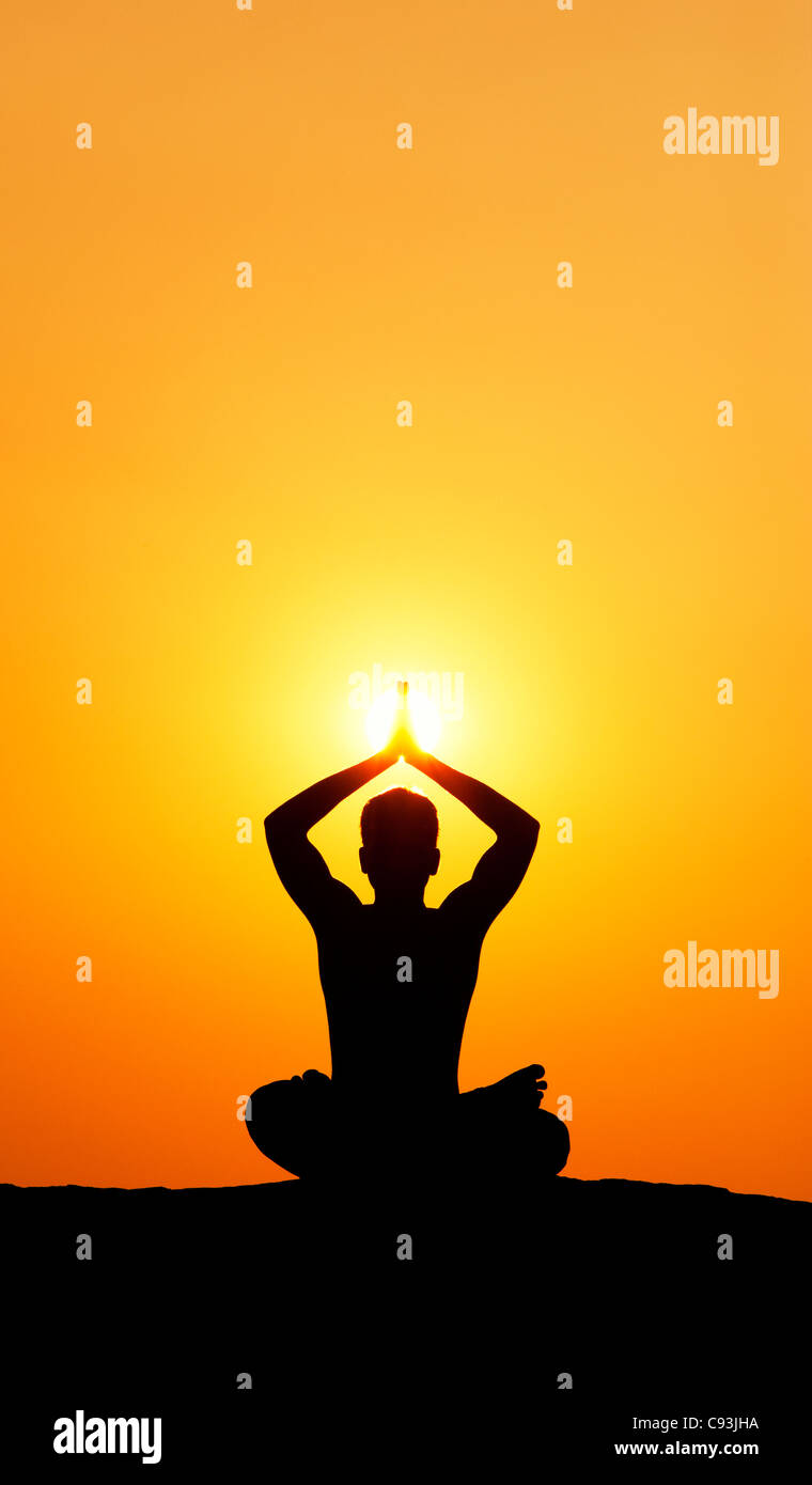 Indian man offering prayers to the sun at sunset. Silhouette. India ...