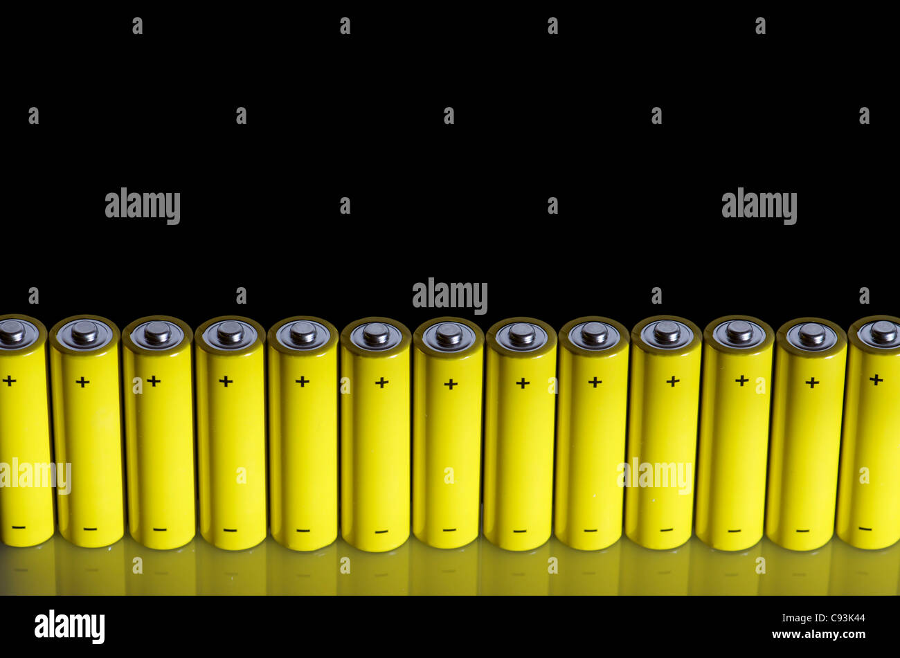set of AA batteries lined up on a black background Stock Photo - Alamy
