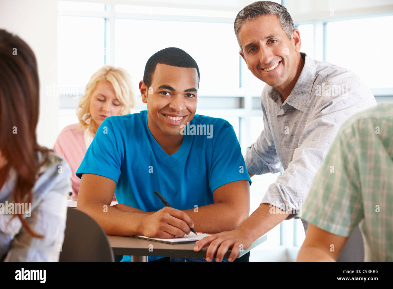 Tutor helping student in class Stock Photo - Alamy