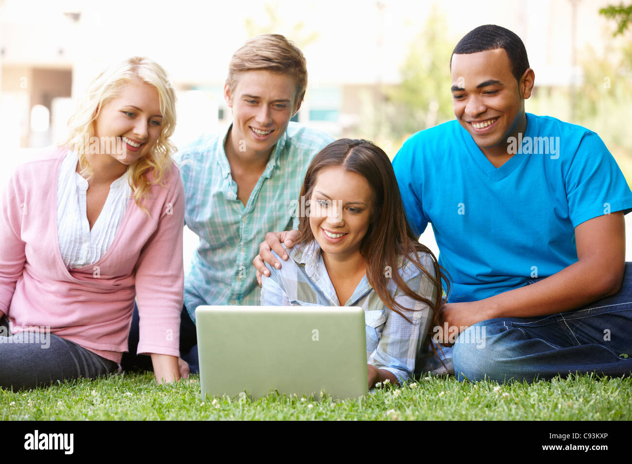 Young people using laptop outdoors Stock Photo - Alamy