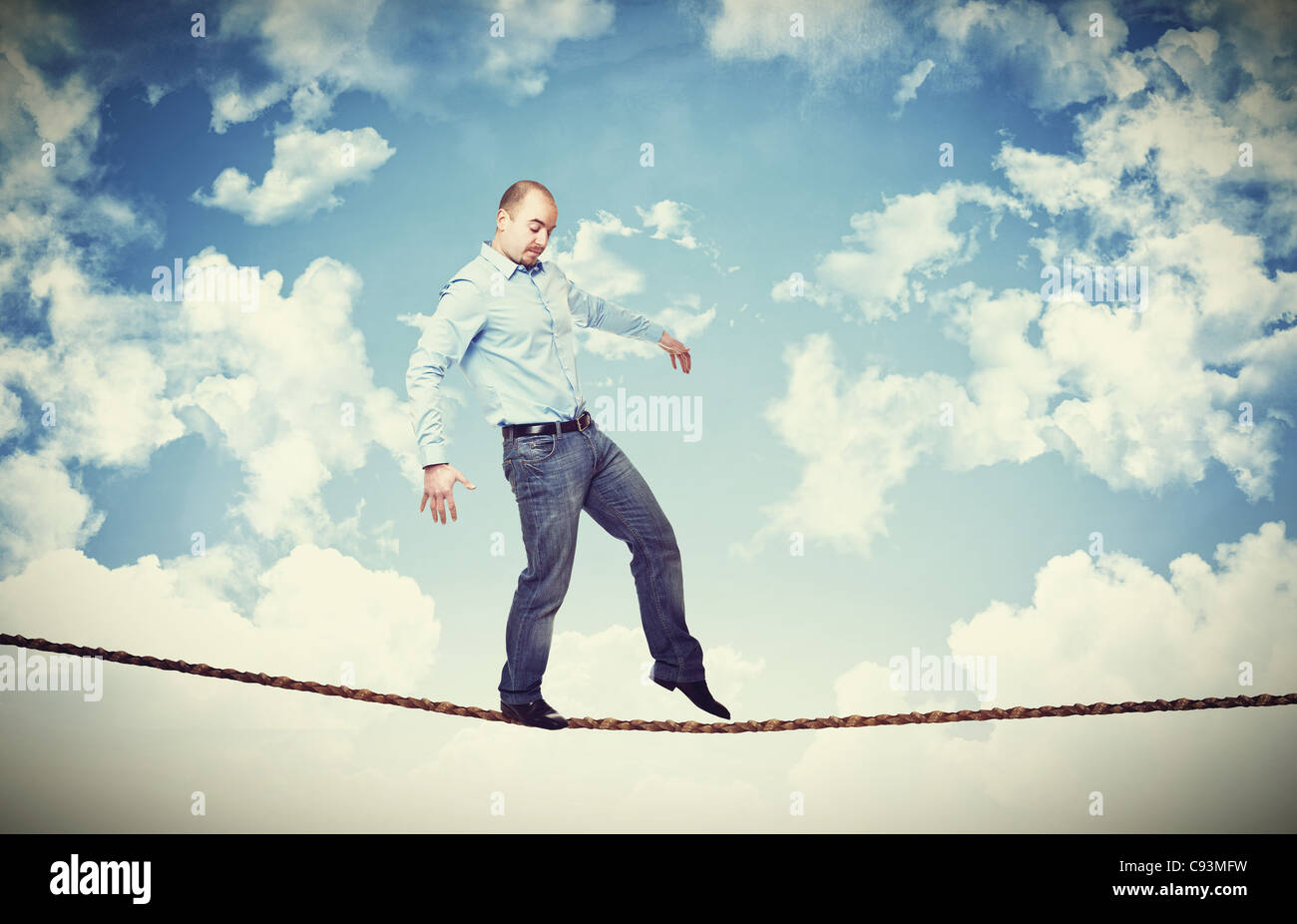 man walk on rope with blue sky background Stock Photo - Alamy
