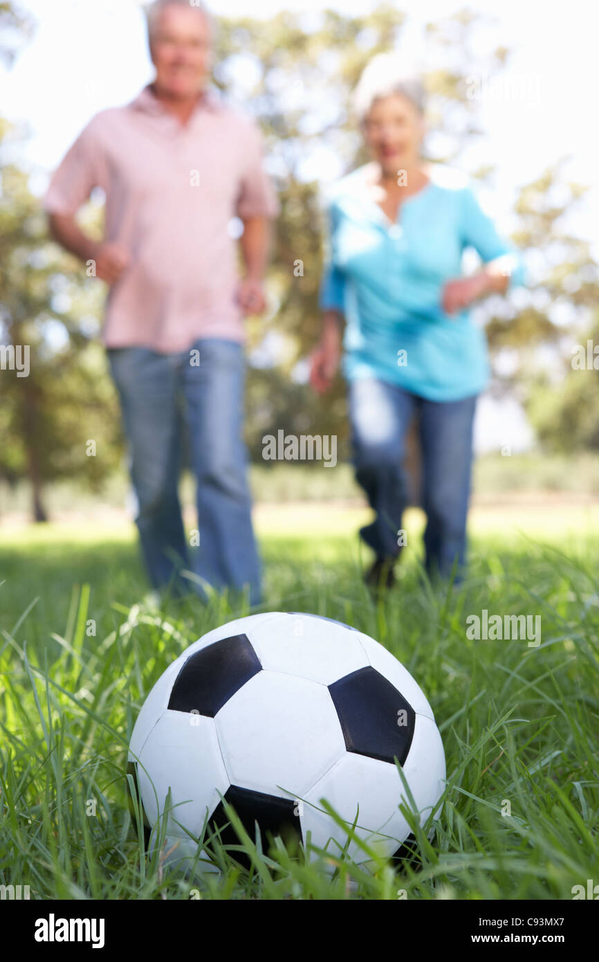 Senior couple playing football Stock Photo - Alamy