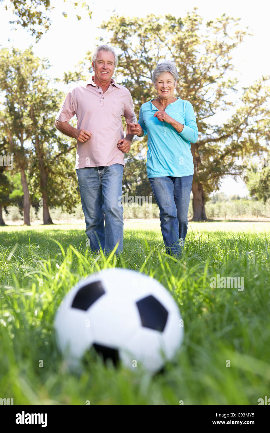 Senior couple playing football Stock Photo - Alamy
