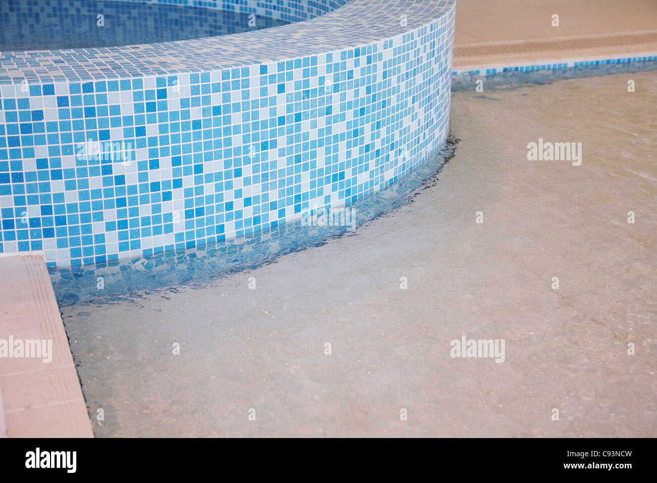A jacuzzi with blue mosaic tiles at the side of a swimming pool Stock ...