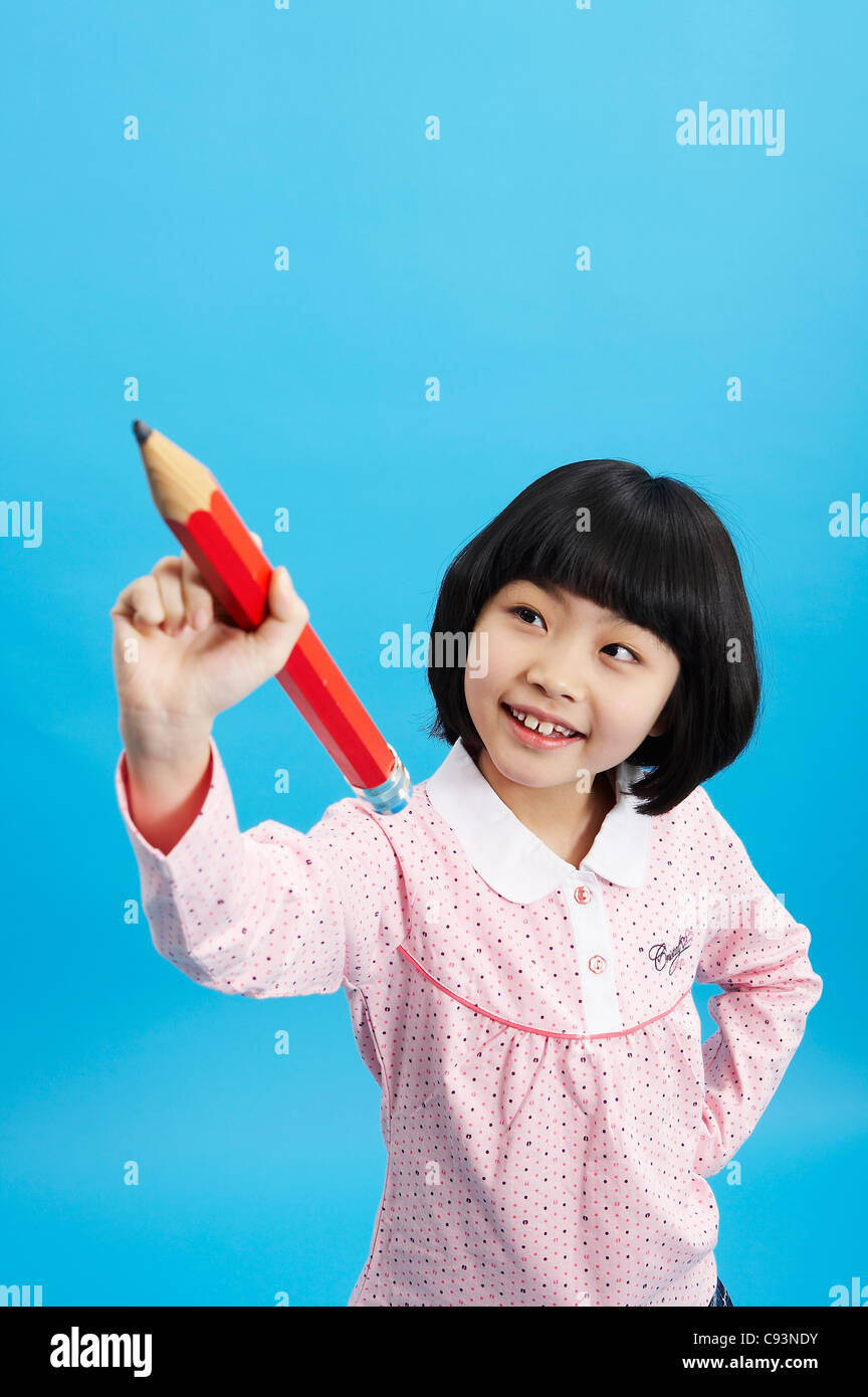 Young girl with big pencil, thinking, studio shot Stock Photo - Alamy