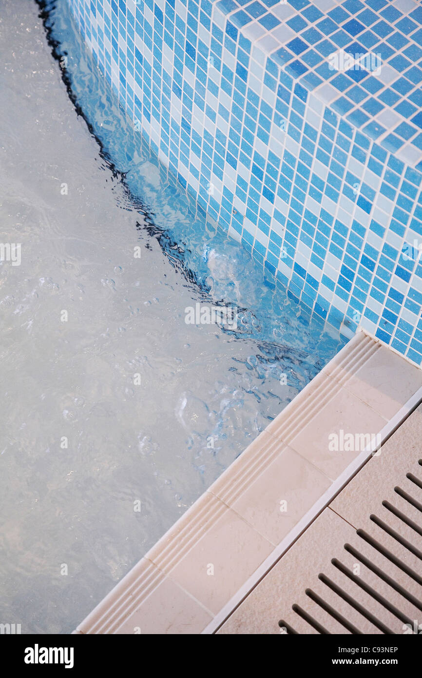A jacuzzi with blue mosaic tiles at the side of a swimming pool Stock ...