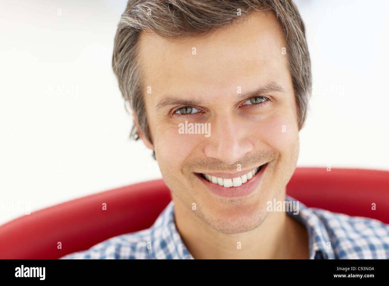 Man sitting in red chair Stock Photo - Alamy