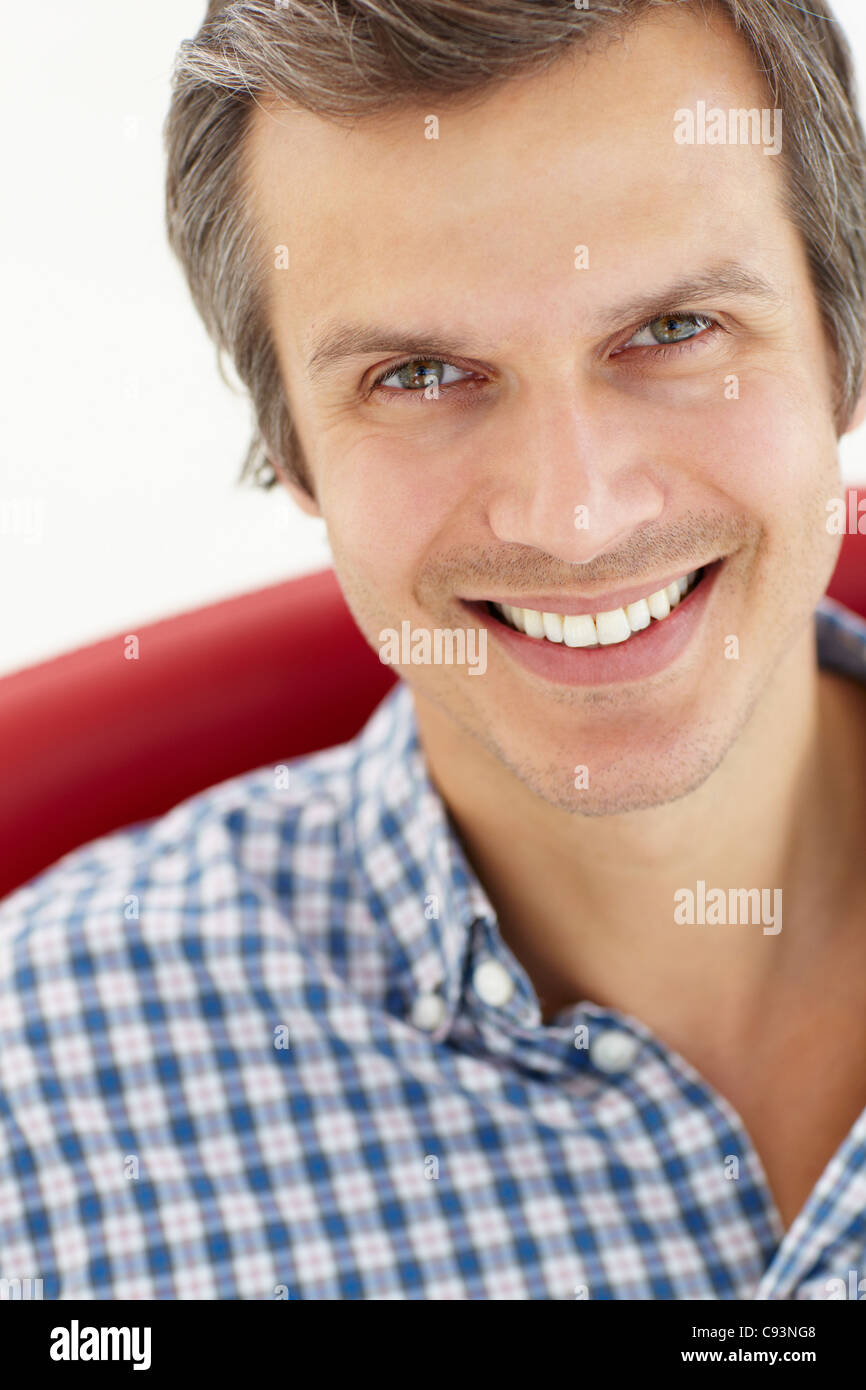 Man sitting in red chair Stock Photo - Alamy