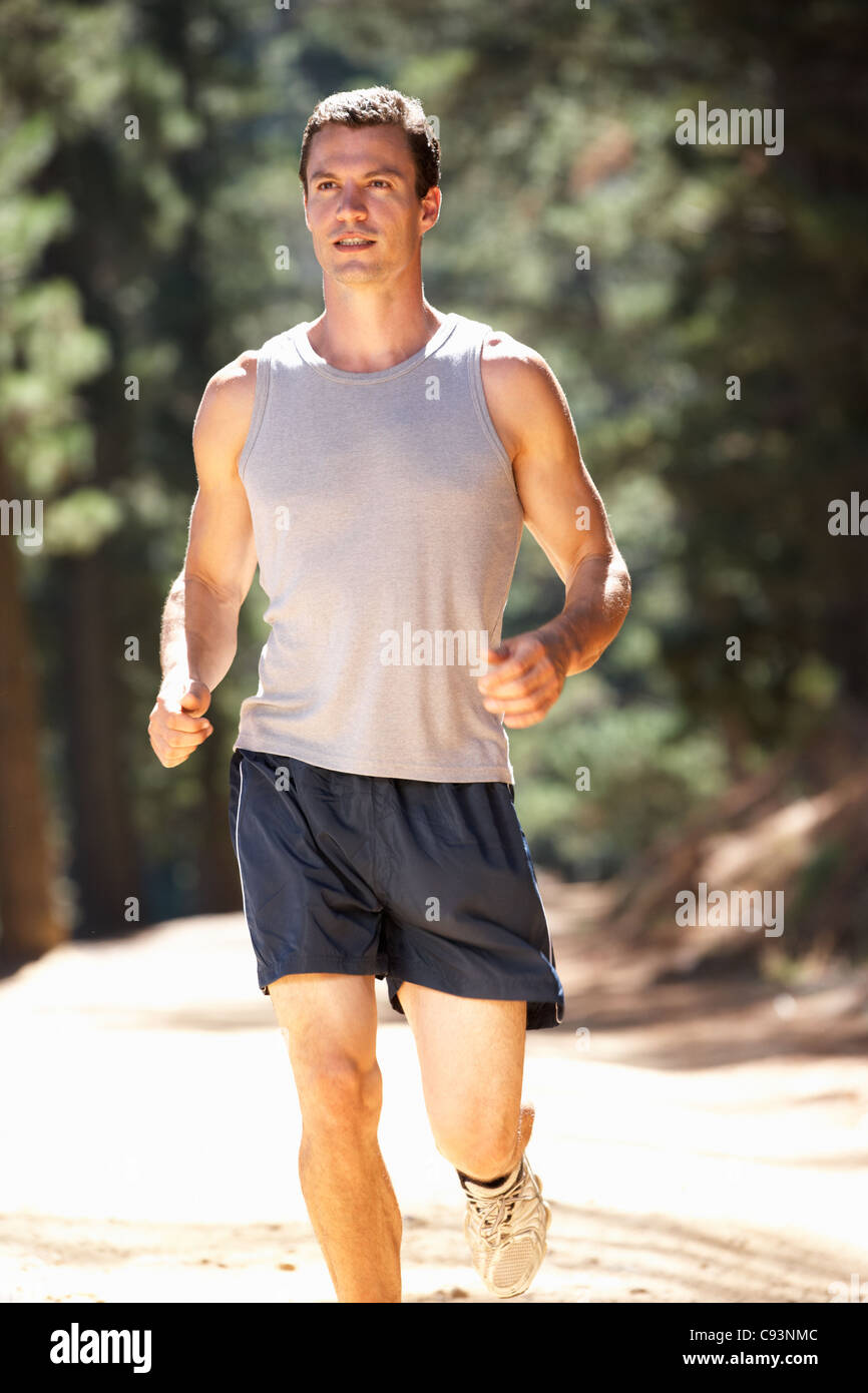 Young man running along country lane Stock Photo - Alamy