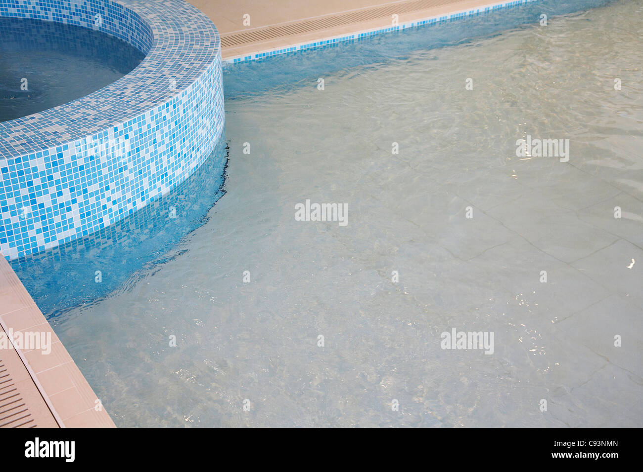 A jacuzzi with blue mosaic tiles at the side of a swimming pool Stock ...