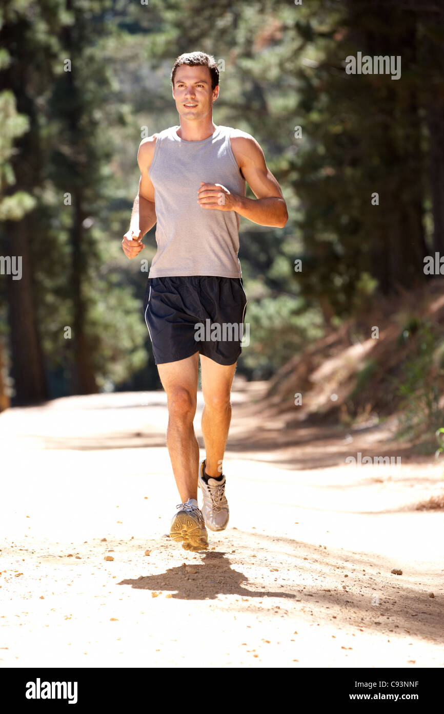 Young man running along country lane Stock Photo - Alamy