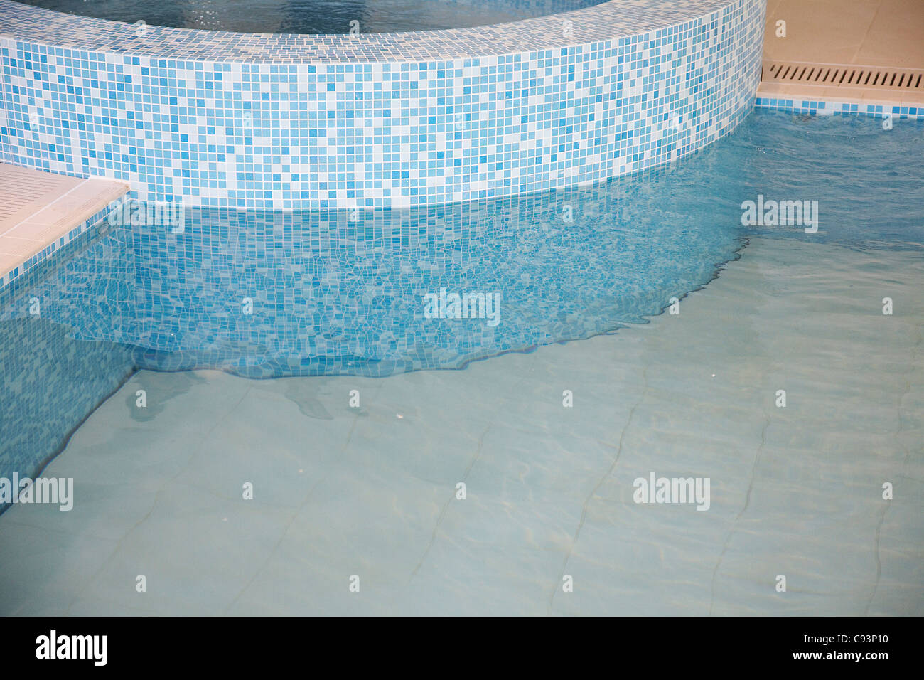 A jacuzzi with blue mosaic tiles at the side of a swimming pool Stock ...
