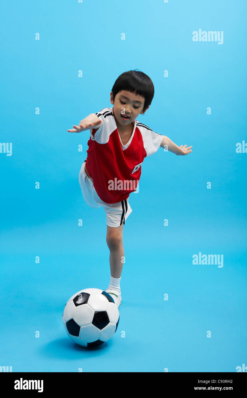 Boy kicking football indoors hi-res stock photography and images - Alamy