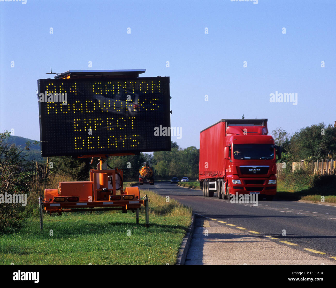 roadside electronic warning sign of roadworks and delays on road ahead ...