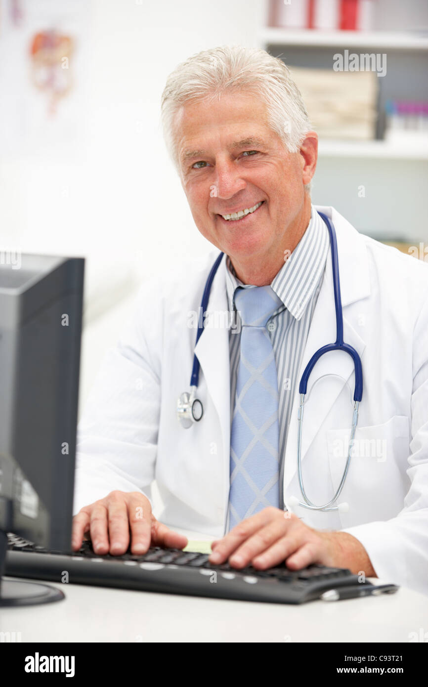 Senior doctor at desk Stock Photo - Alamy