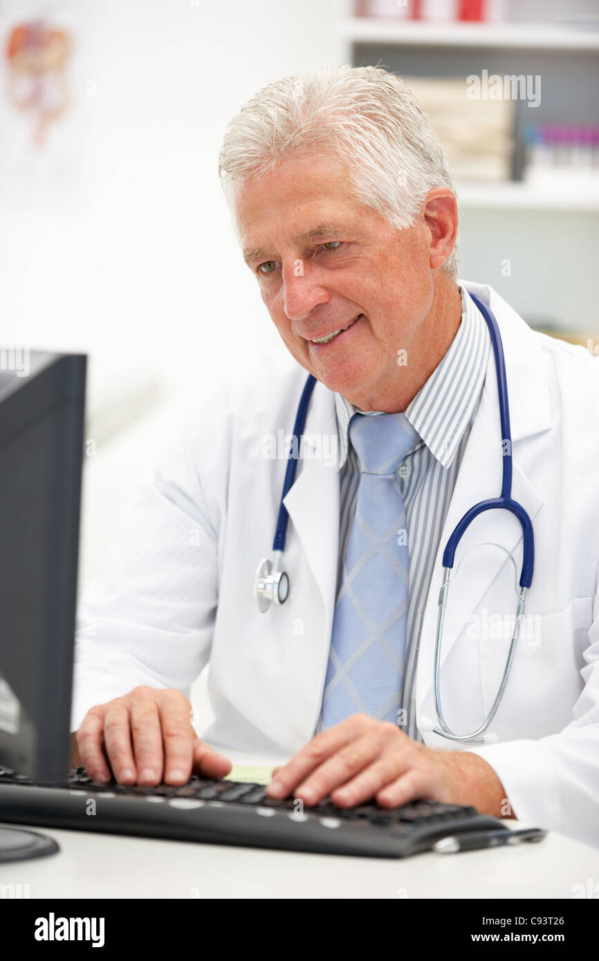 Senior doctor at desk Stock Photo - Alamy