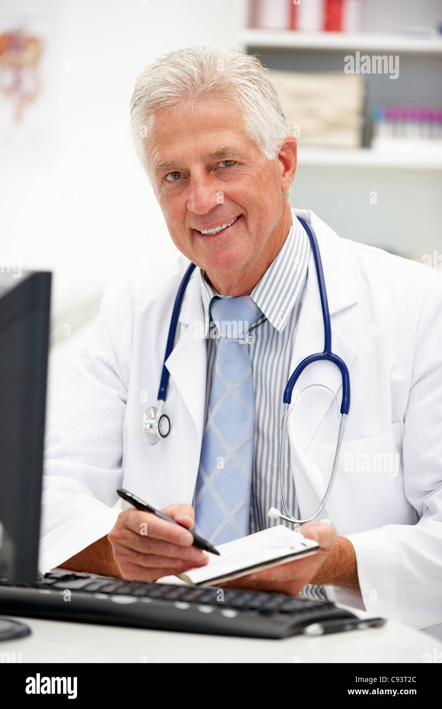 Senior doctor at desk Stock Photo - Alamy