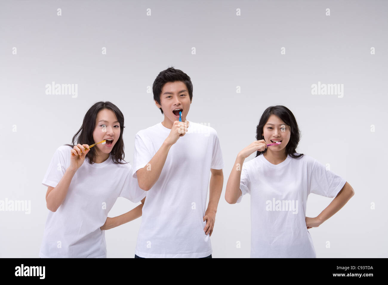 Three friends brushing their teeth in studio, portrait Stock Photo - Alamy