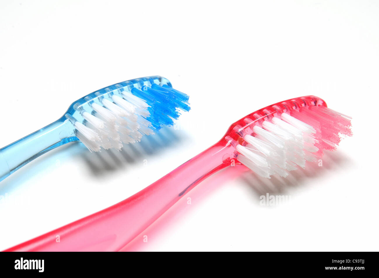 Red and blue colored toothbrushes on white background Stock Photo - Alamy