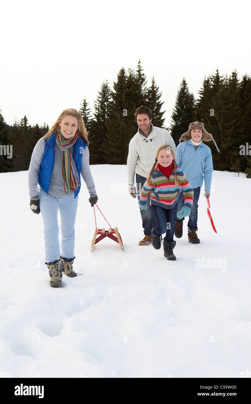 Young Family Walking Through Snow With Sled Stock Photo - Alamy