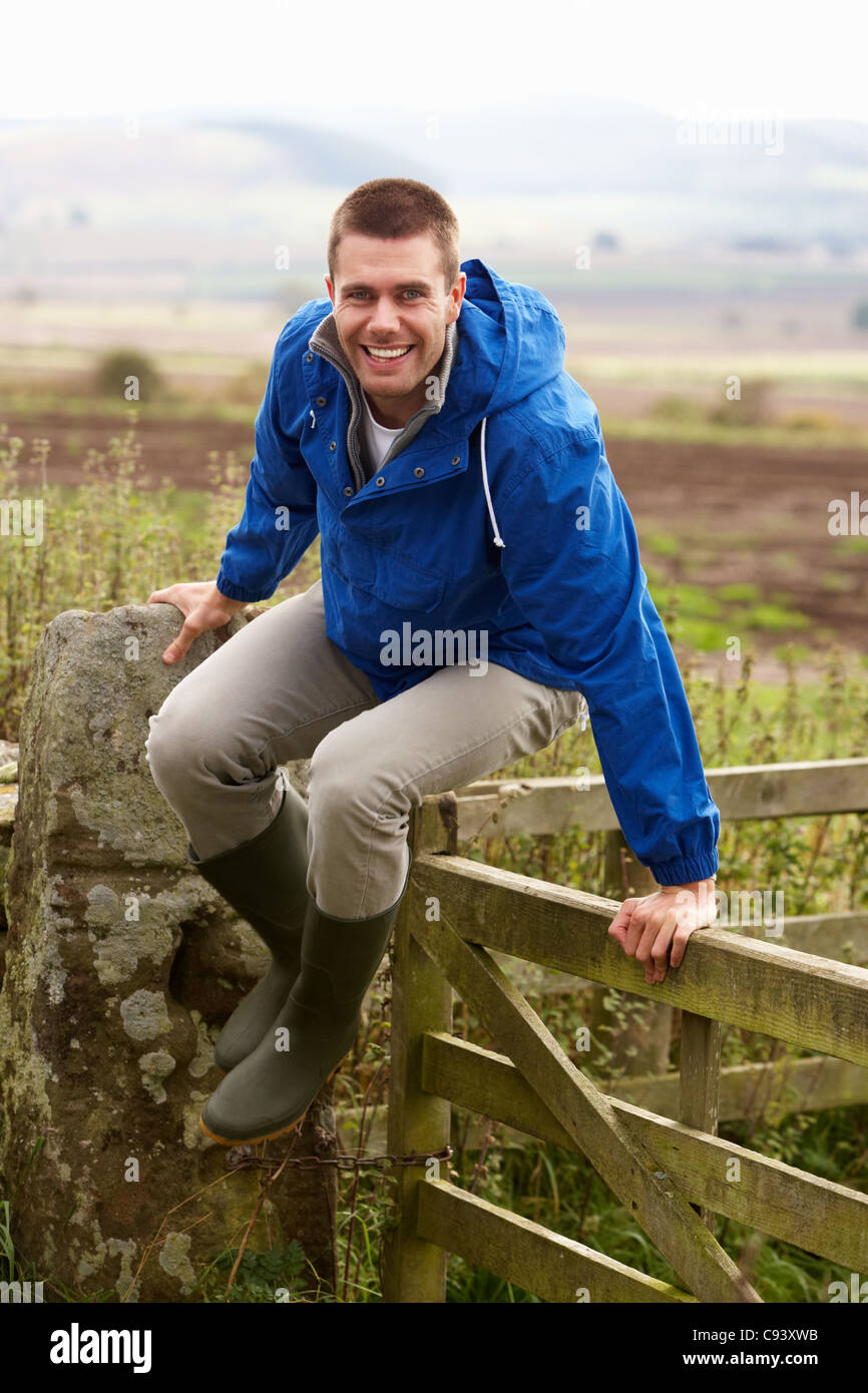 Man jumping over country gate Stock Photo - Alamy