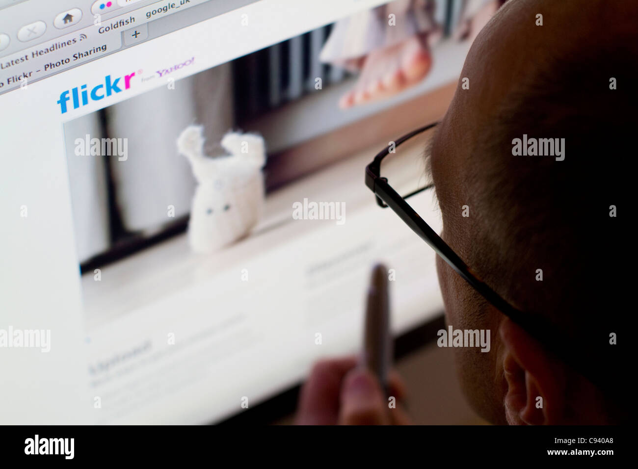 Close-up of a man browsing the Flickr website on a computer, searching ...