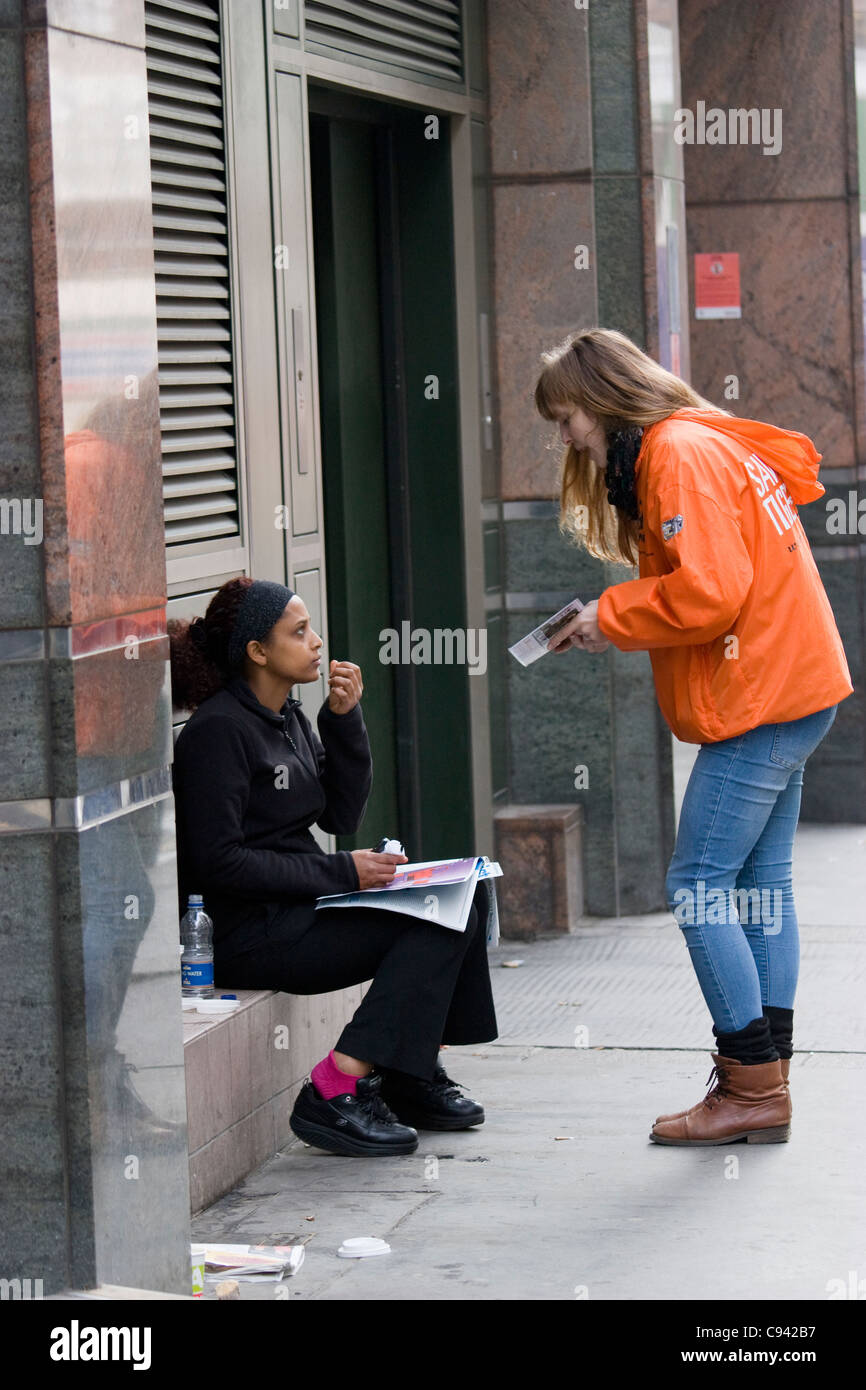 Charity workers, known as "chuggers," engage with passersby on a busy ...