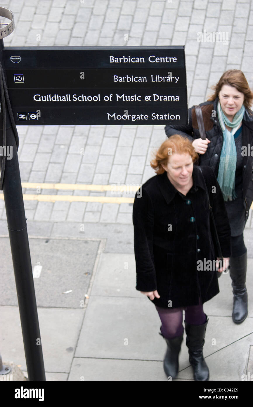 pedestrians walk under Barbican centre signs, barbican London Stock ...