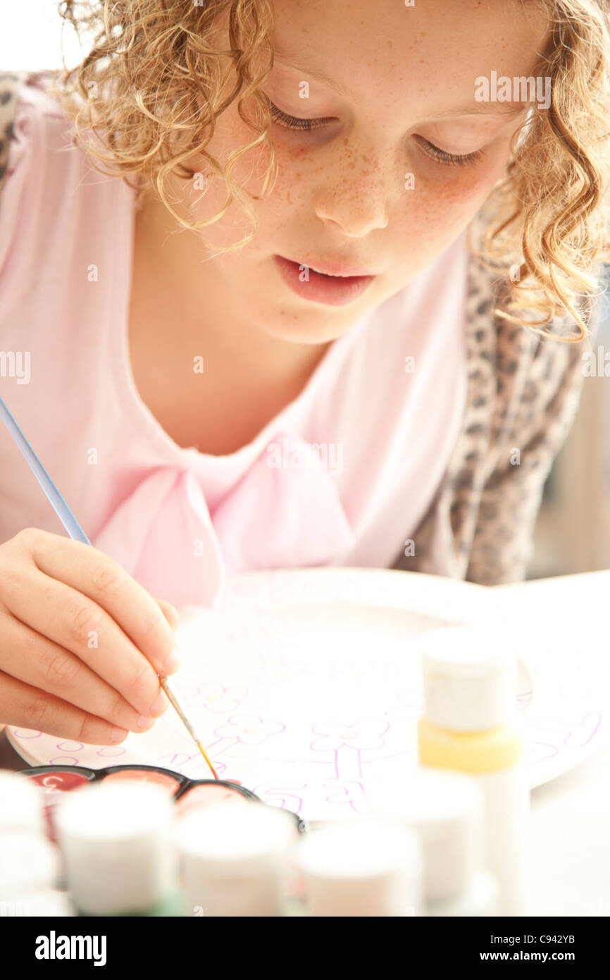 Girl Painting on Ceramic Plate Stock Photo - Alamy