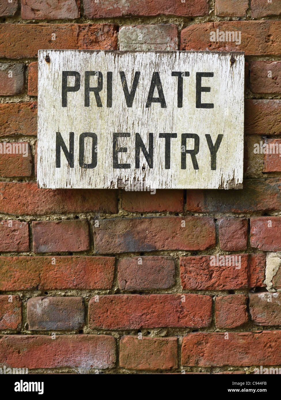 Decaying Private, No Entry sign fixed to weathered brick wall. Vertical ...