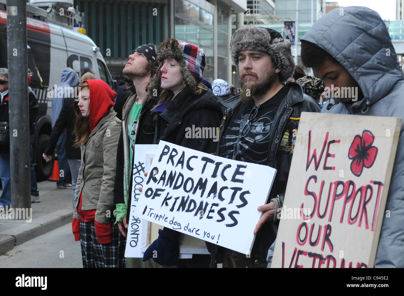 A group of five unidentified Occupy Toronto protesters joins in the ...