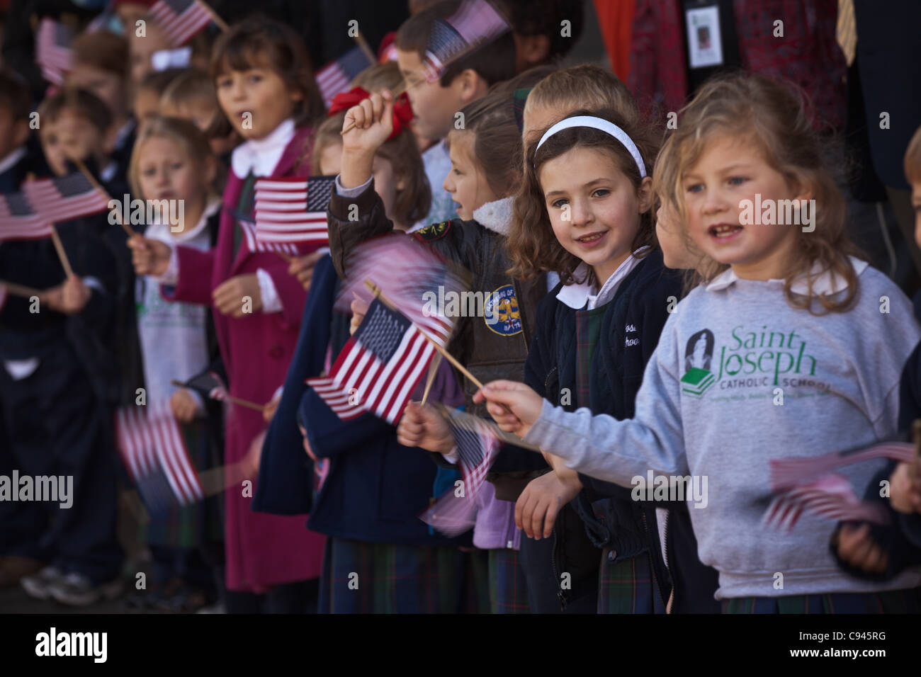 School children wave flags during the annual Veterans Day parade on ...
