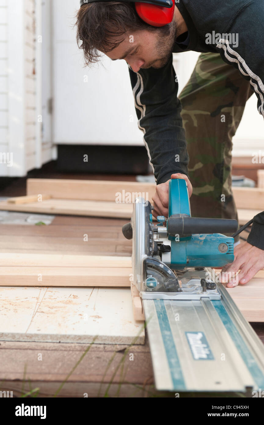 Carpenter sawing wood with a circular saw Stock Photo - Alamy