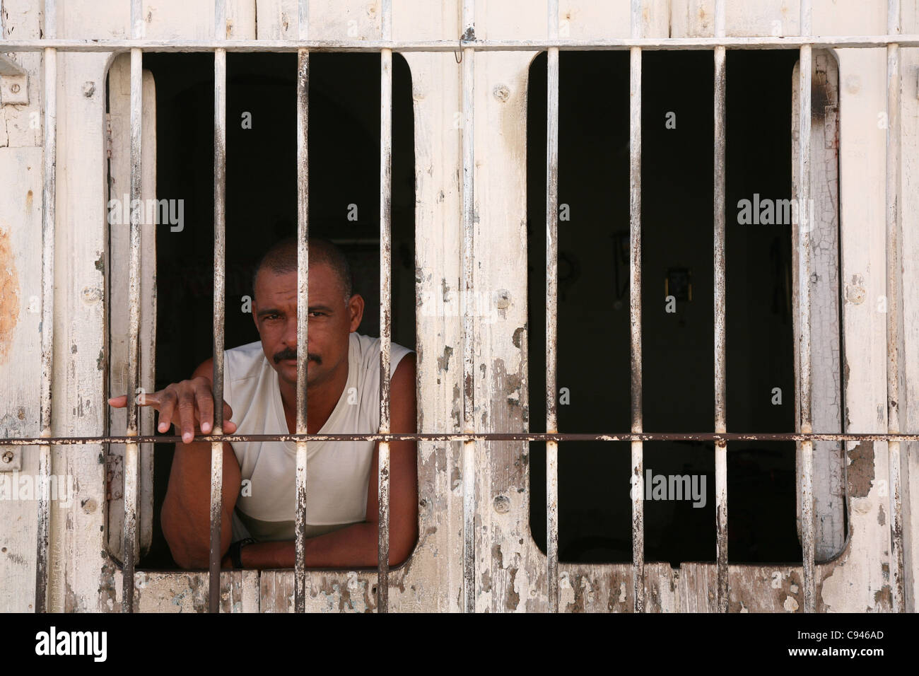 Cuban man behind the traditional barred window in Trinidad, Cuba Stock ...