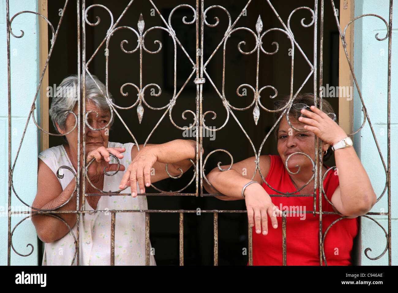 Two Cuban women behind the traditional barred window in Trinidad, Cuba ...