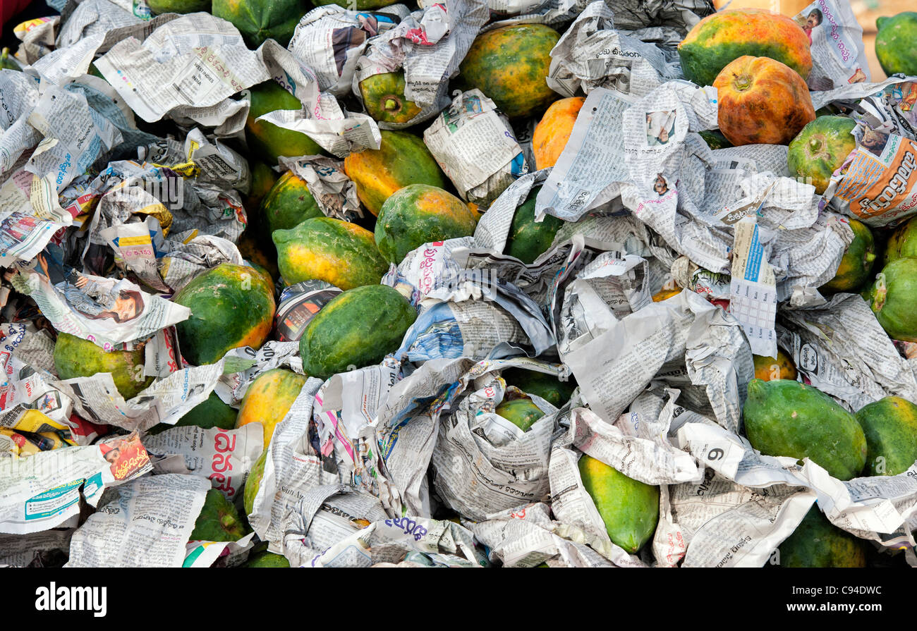 Papaya wrapped in newspaper for sale at an Indian market. Andhra ...