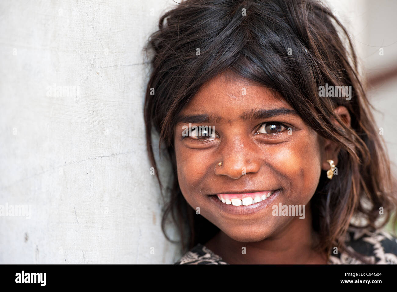Poor Indian nomadic beggar girl smiling side of frame with copy space ...