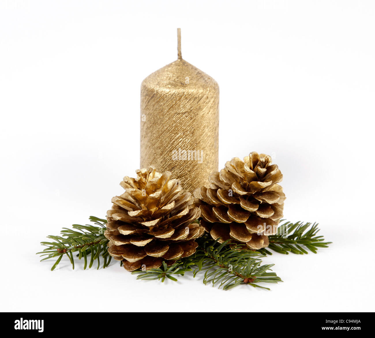 Gold candle with the twig of the spruce and cones Stock Photo - Alamy