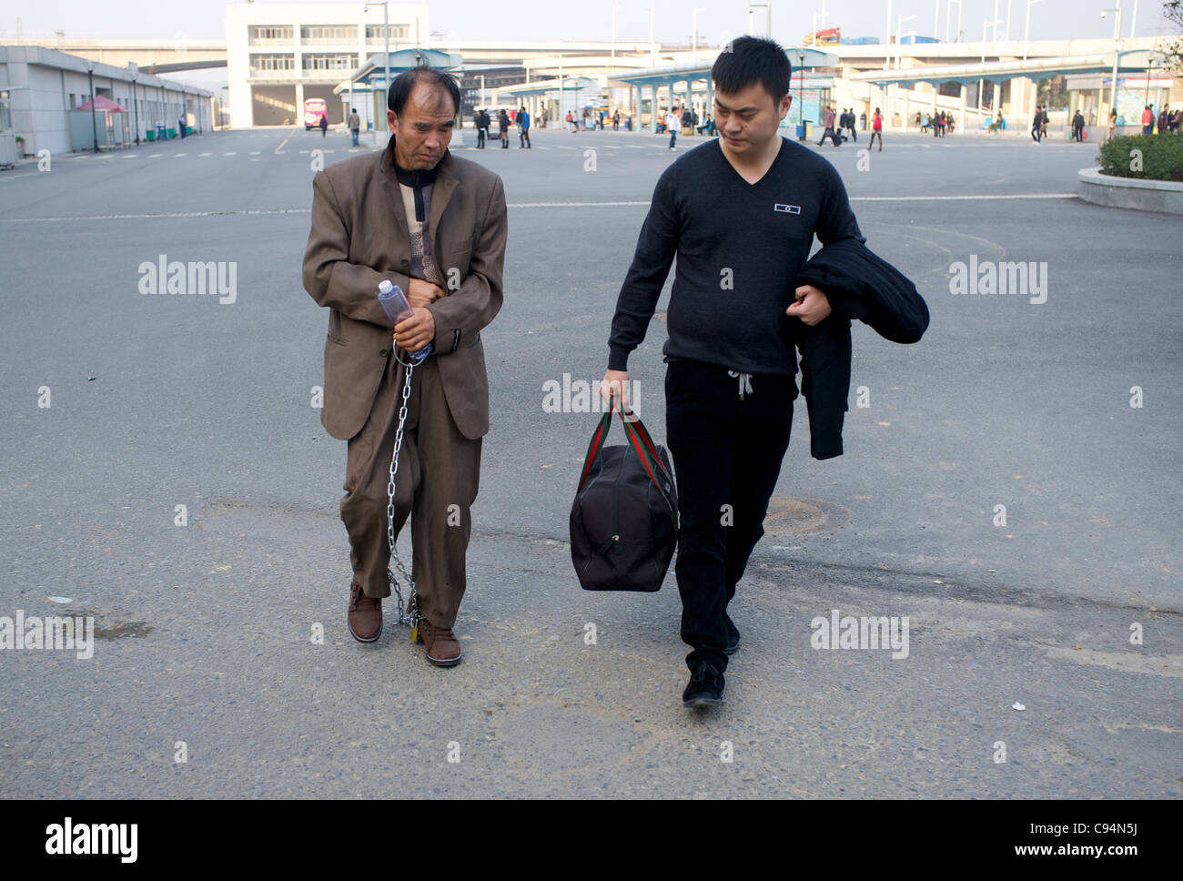 A Chinese man is taken away in handcuffs and shackles by a policeman in ...