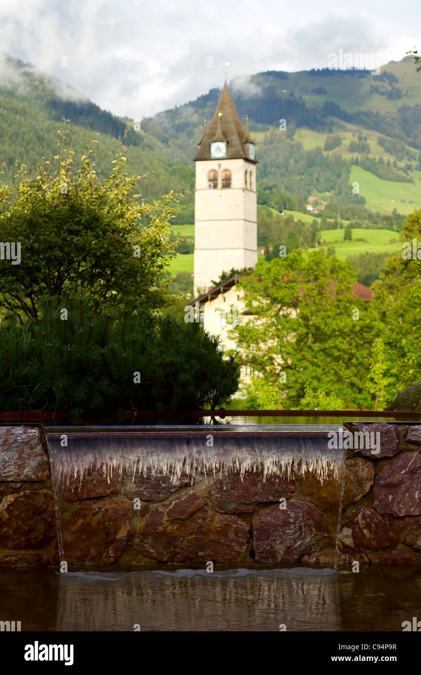 Church in the Austrian Alps in Tirol with an artifical mini waterfall ...