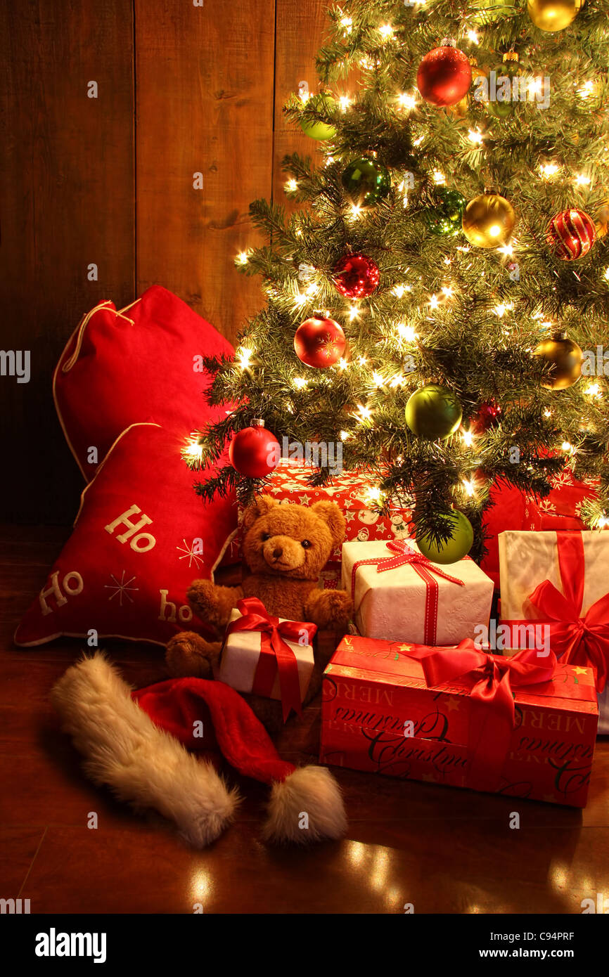 Closeup of brightly lit Christmas tree with gifts Stock Photo - Alamy