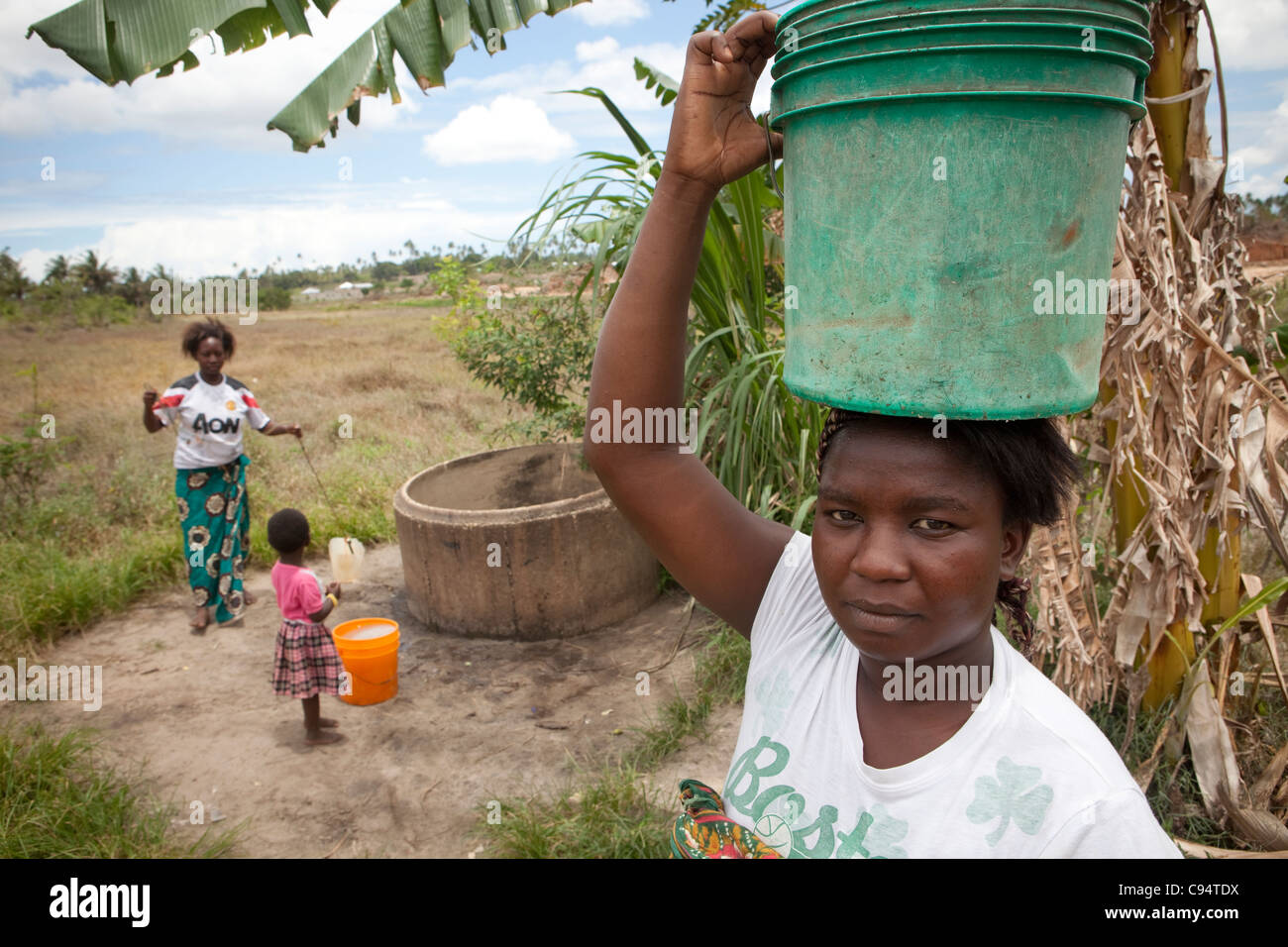 A woman stands at a rural well in a village outside Dar es Salaam ...