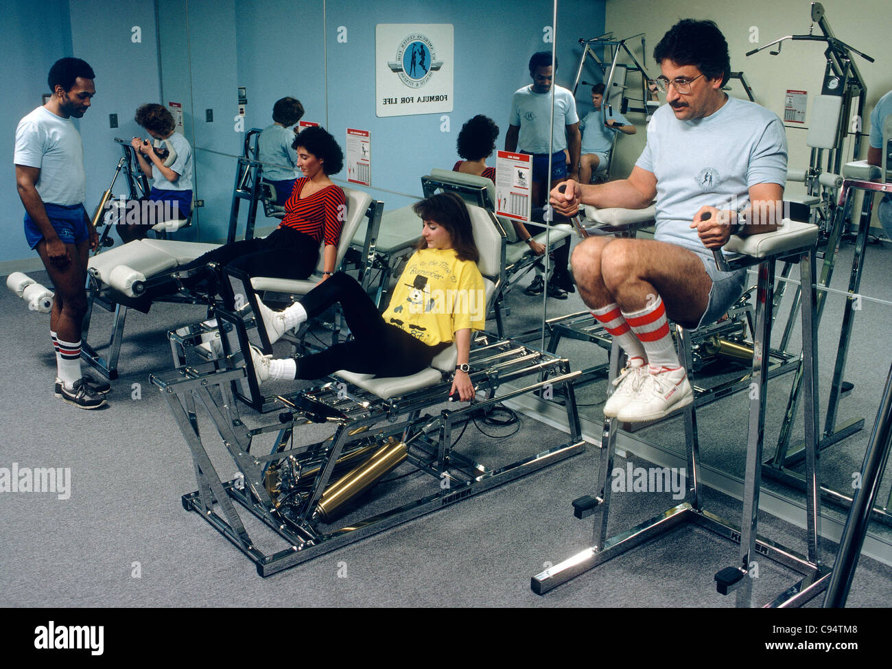 Employees working out at an exercise facility in a corporate gymnasium ...