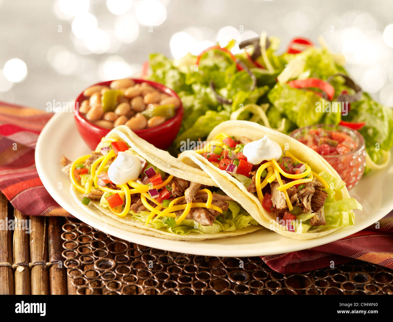 Two soft carnitas tacos served with side salad and pinto beans Stock ...
