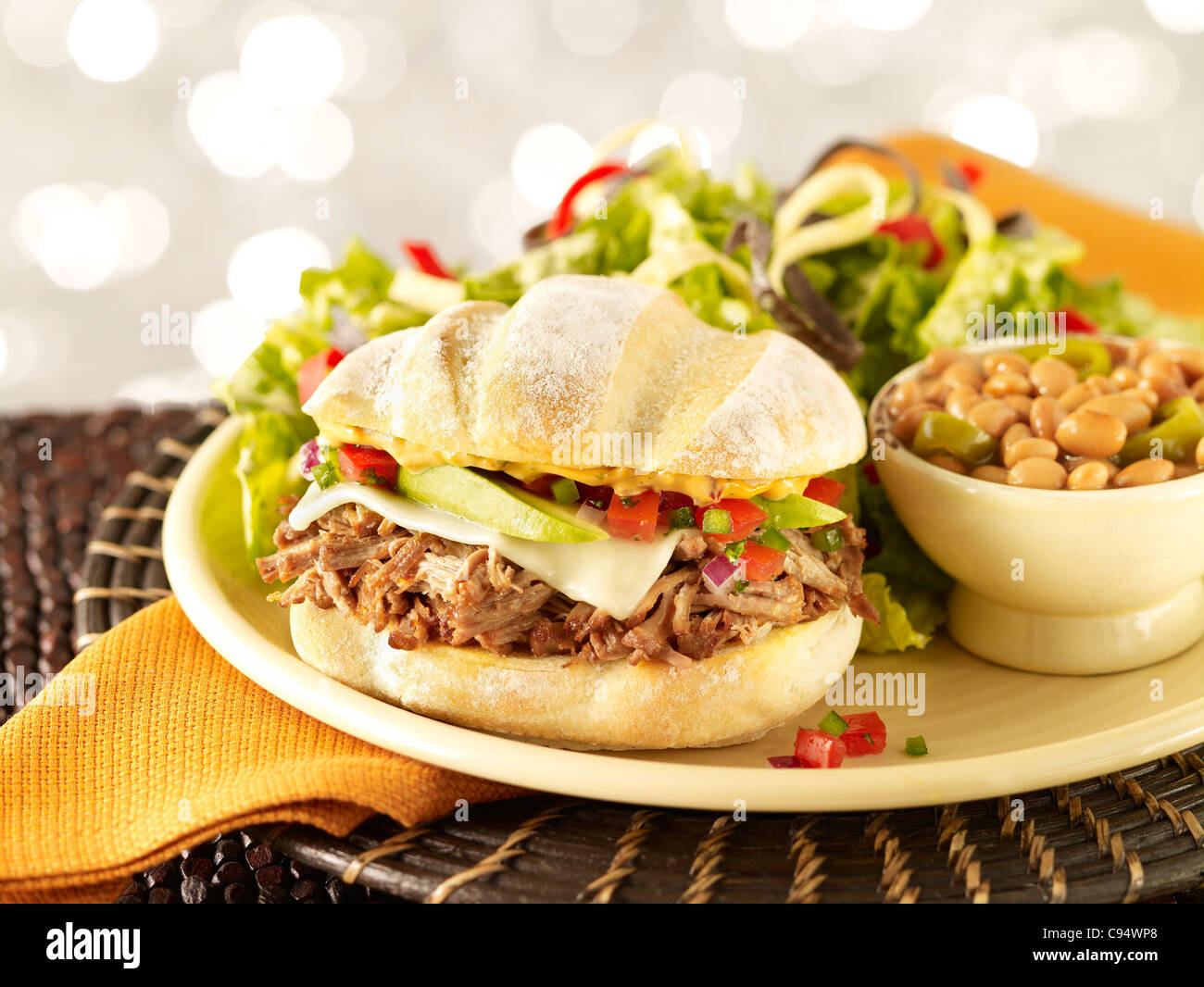 Pork sandwich on artisan bread served with side salad and pinto beans ...