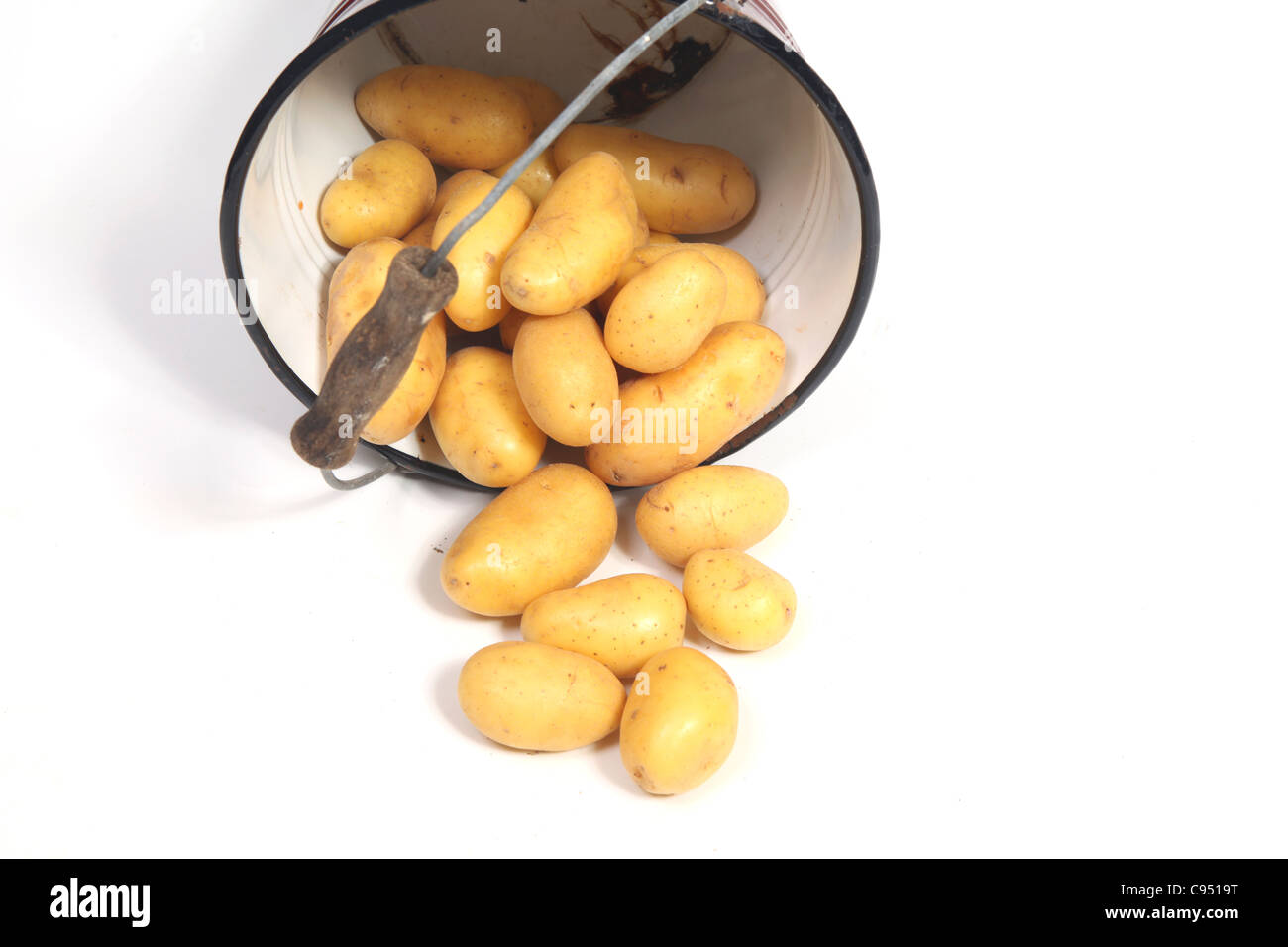 New potatoes falling out of old enamel bucket Stock Photo - Alamy