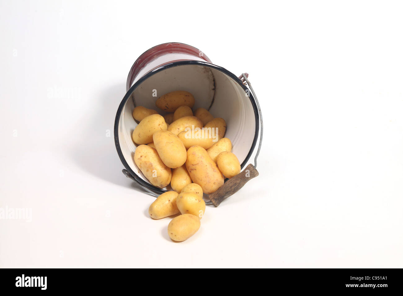 Old enamel bucket with spilled potatoes Stock Photo - Alamy