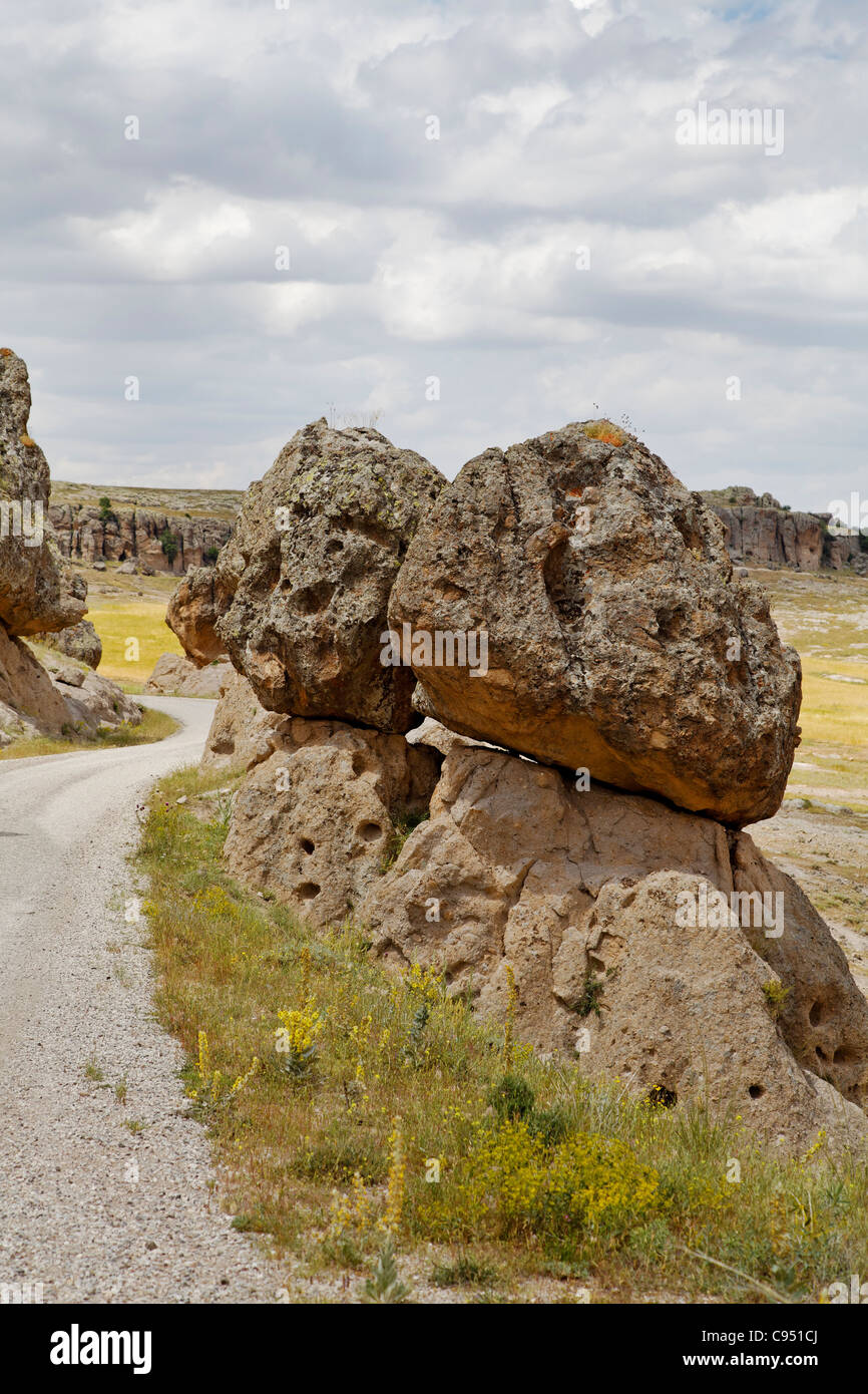 volcanic lava boulders balanced on another by the gravel dirt track ...