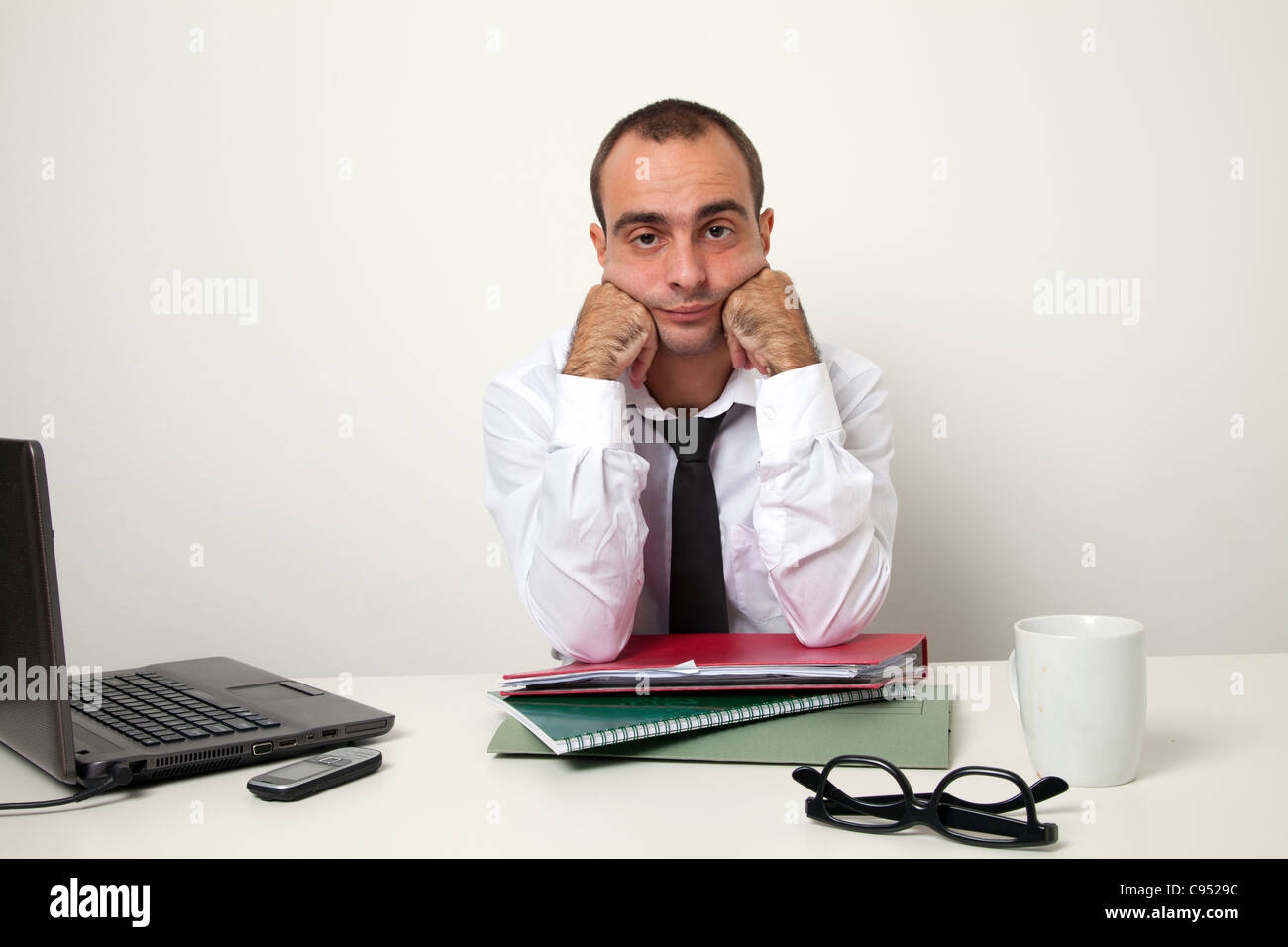 Bored man at work desk Stock Photo - Alamy