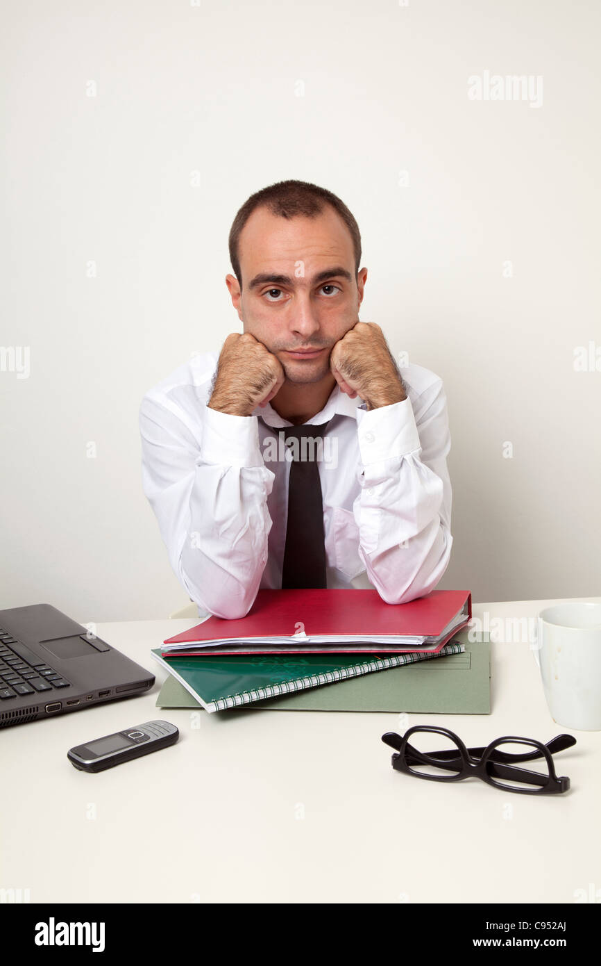 Bored man at work desk Stock Photo - Alamy